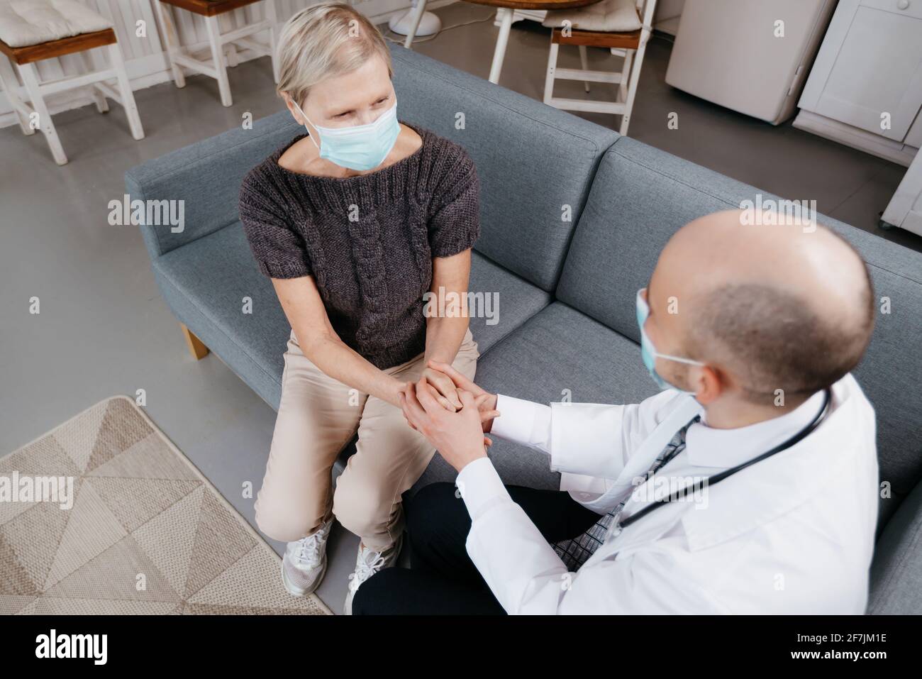 doctor calming an agitated patient during a home visit Stock Photo - Alamy