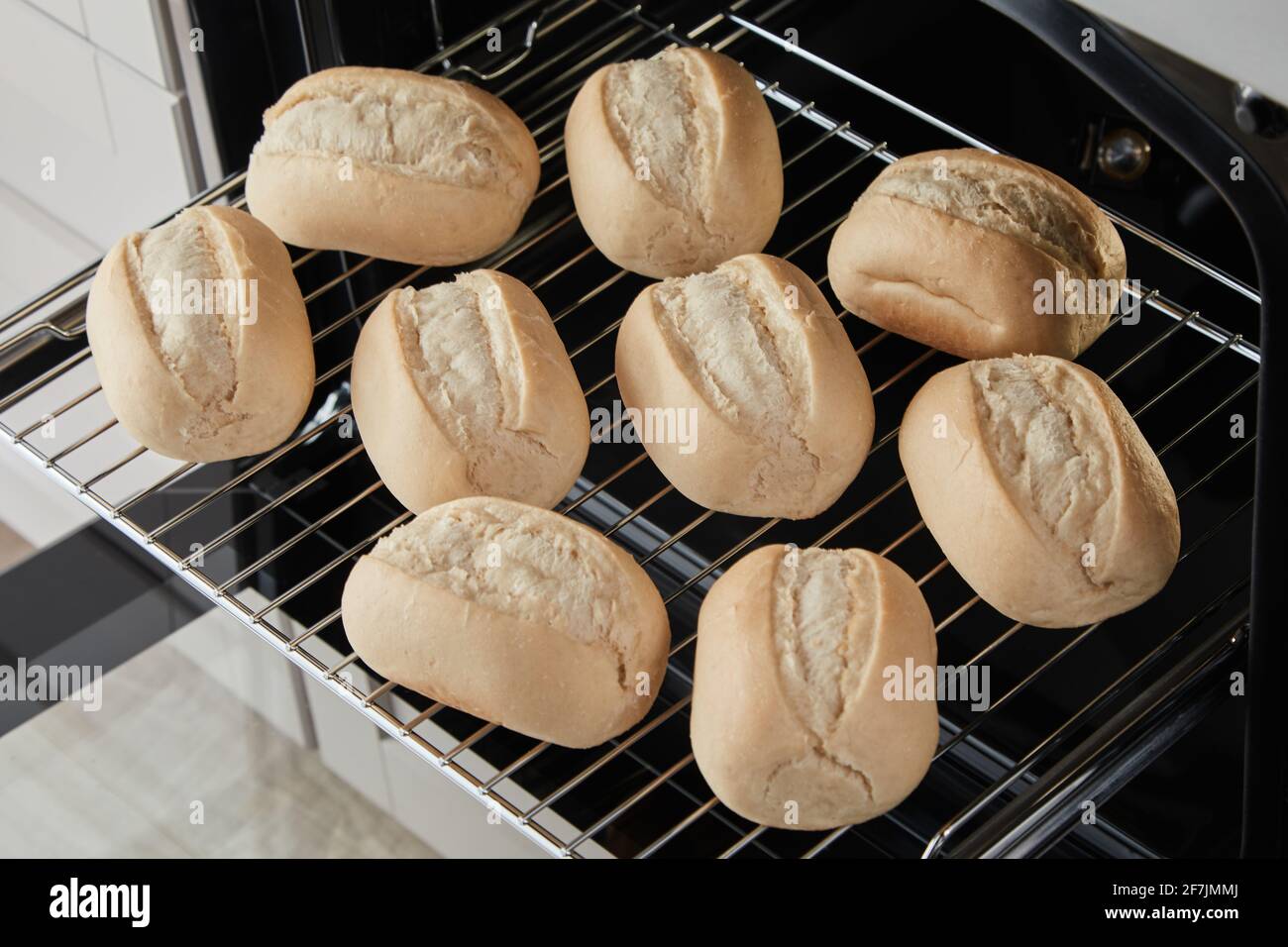 From above of half baked roll buns placed on glide rack of modern oven ...