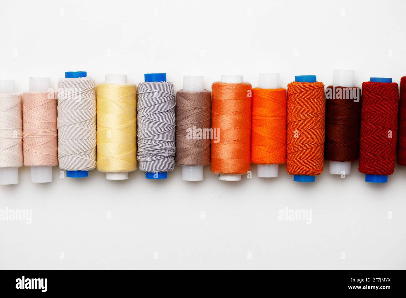 Colored spools of threads on white background Stock Photo - Alamy