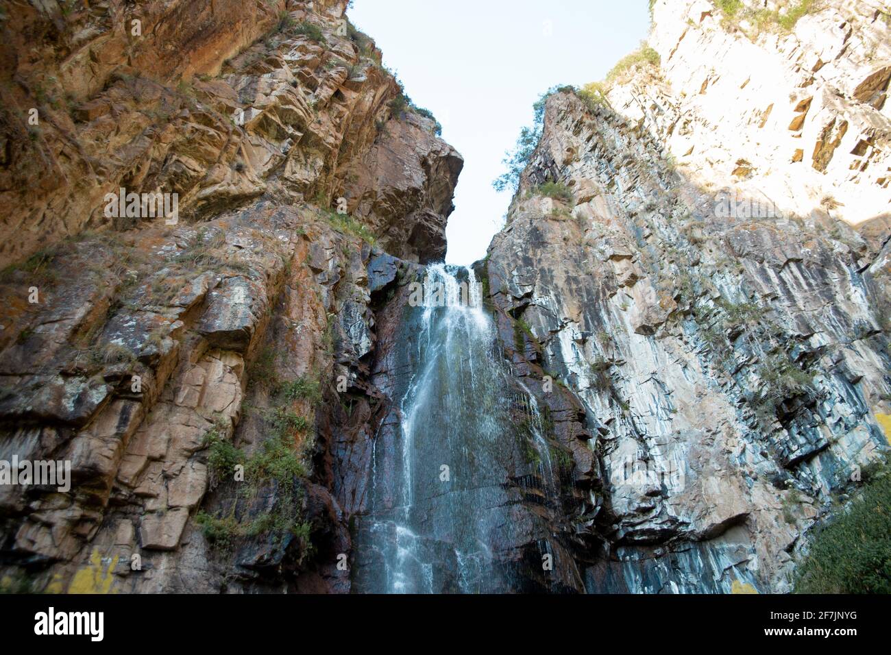 waterfall among rocks in a mountain stream. Water landscape surrounded ...
