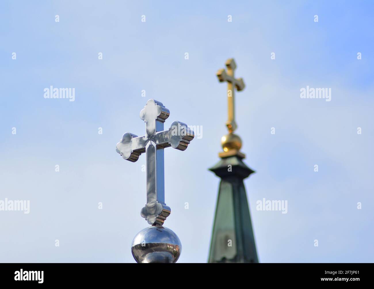 two metal crosses with a blue sky in background Stock Photo - Alamy