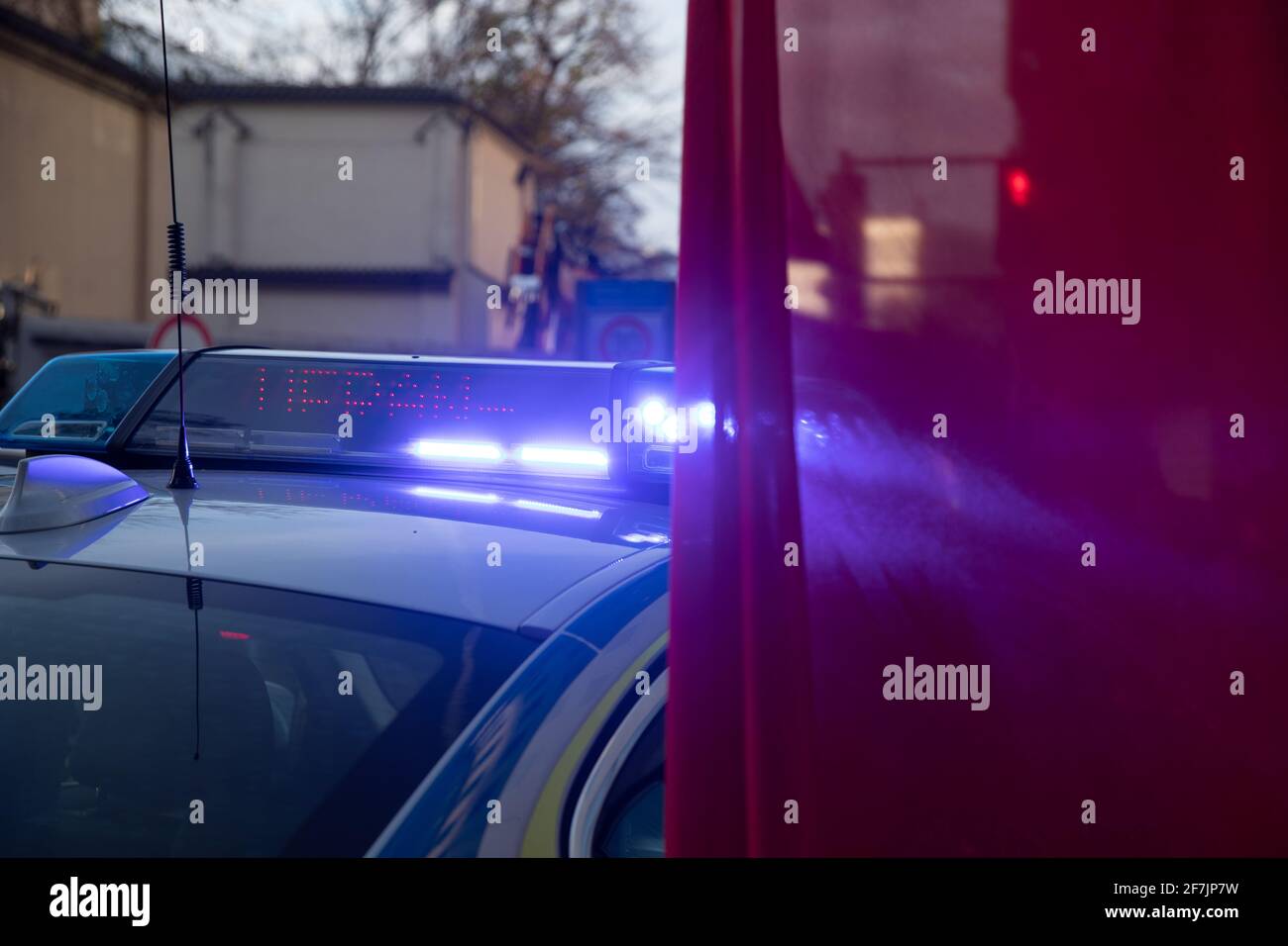 Rotes Tuch steht vor Polizeiwagen mit Blaulicht im Einsatz. -- Red flag ...