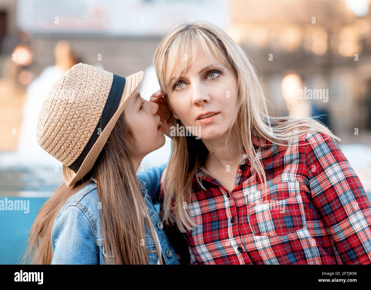 daughter telling something mother in the ear in the city Stock Photo ...