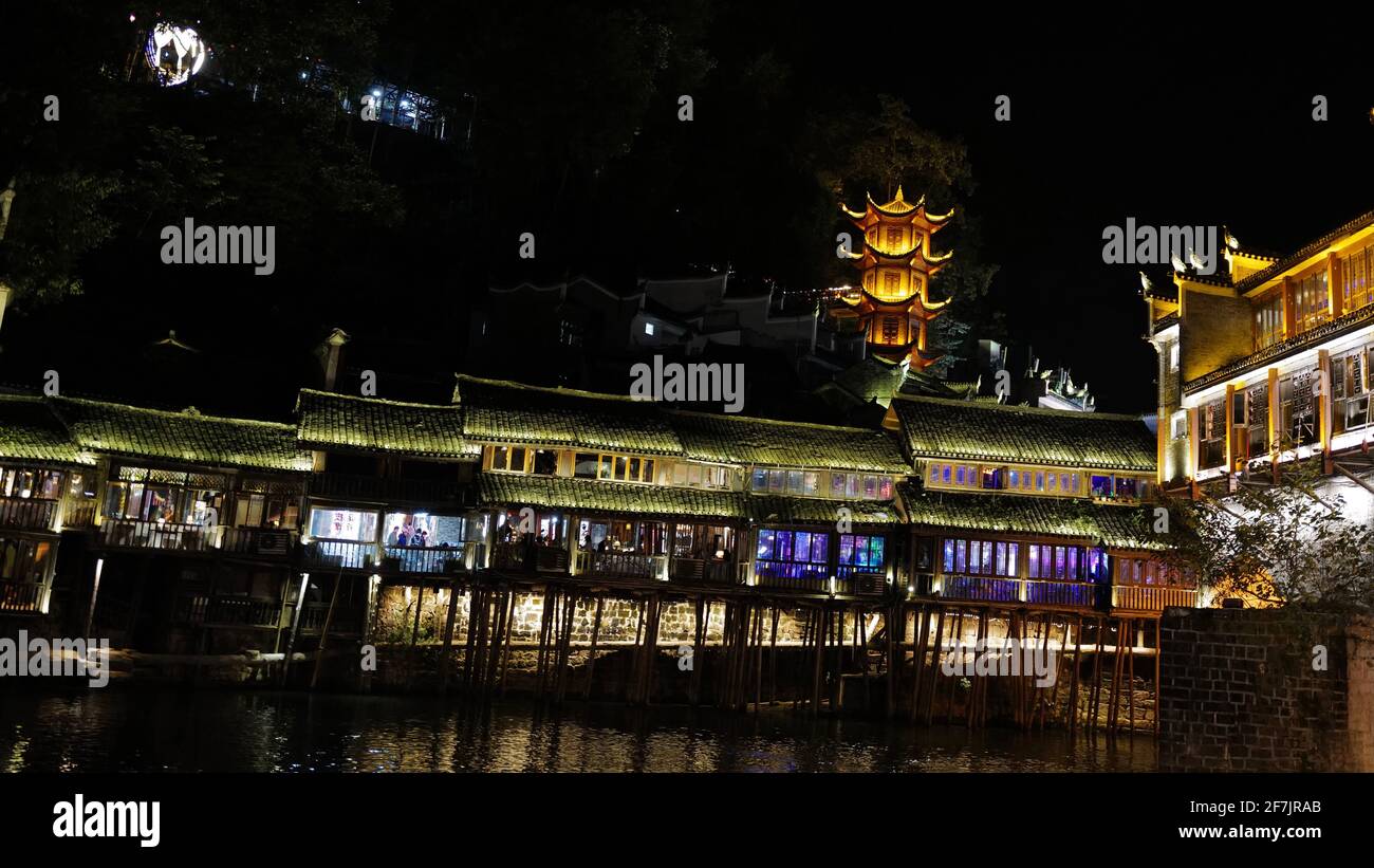 Small town with lights on and its reflaction on water Stock Photo - Alamy