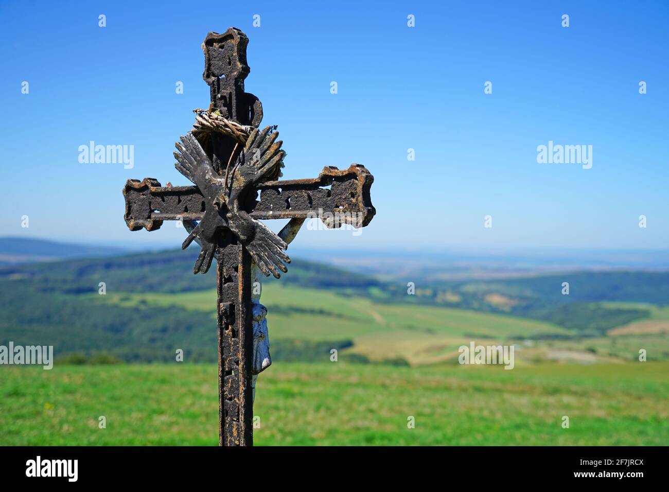 Vintage rustic cross on the grassy hill and blue sky with blurred ...