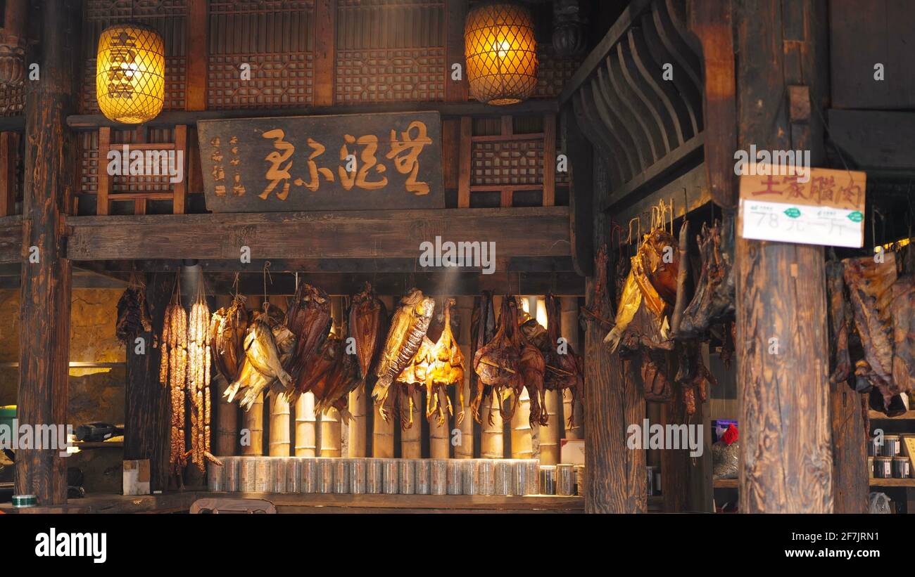 An old style shop with smoked fishes, sausages and lantern hanging ...