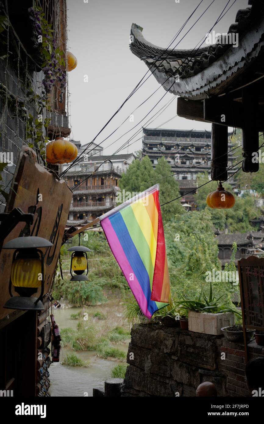A colourful rainbow flag hanging in front of gay bar in Pheonix Town of ...