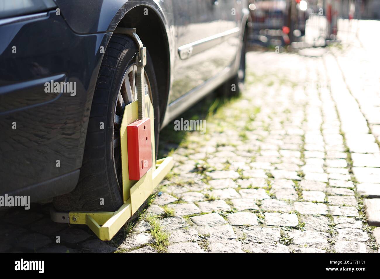 Car on street with wheel clamp, also known as wheel boot, parking boot ...