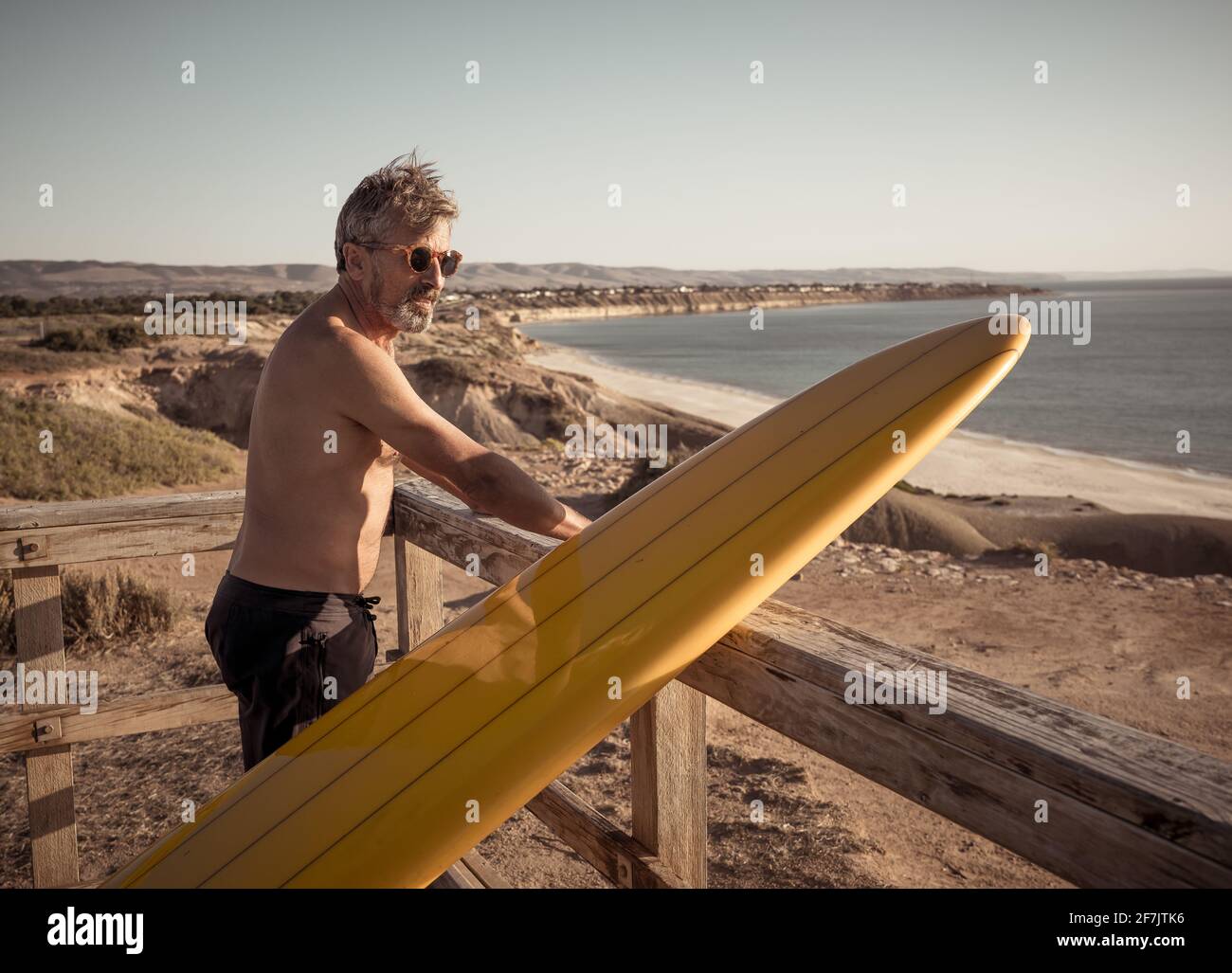 Attractive Australian mature man surfer with cool vintage surfboard on ...