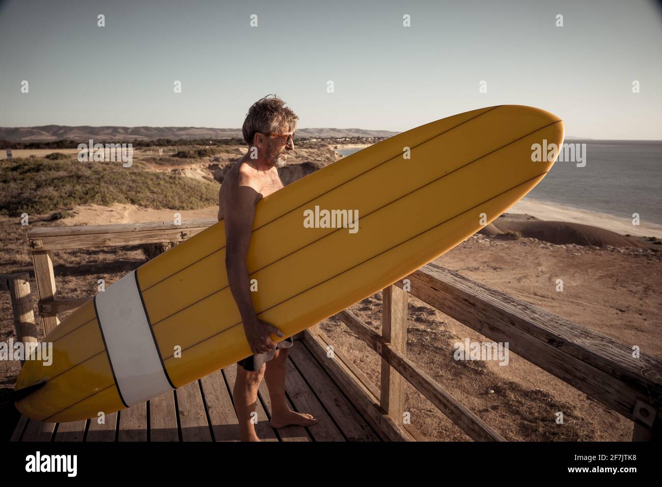Attractive Australian mature man surfer with cool vintage surfboard on ...