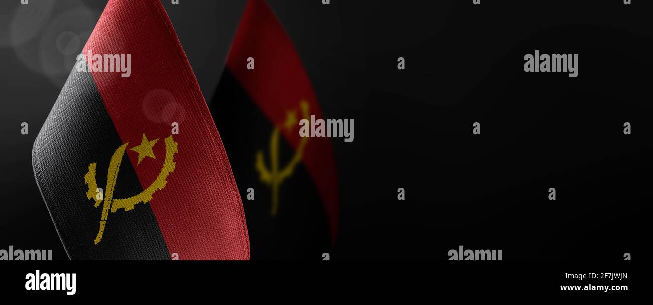 Small national flags of the Angola on a dark background Stock Photo - Alamy