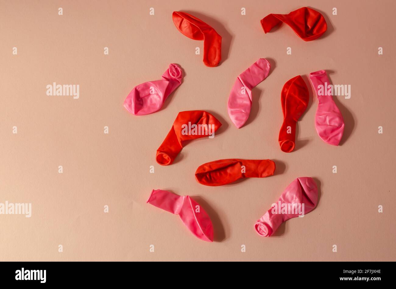 Minimalistic composition with deflated balloons on a pink background ...