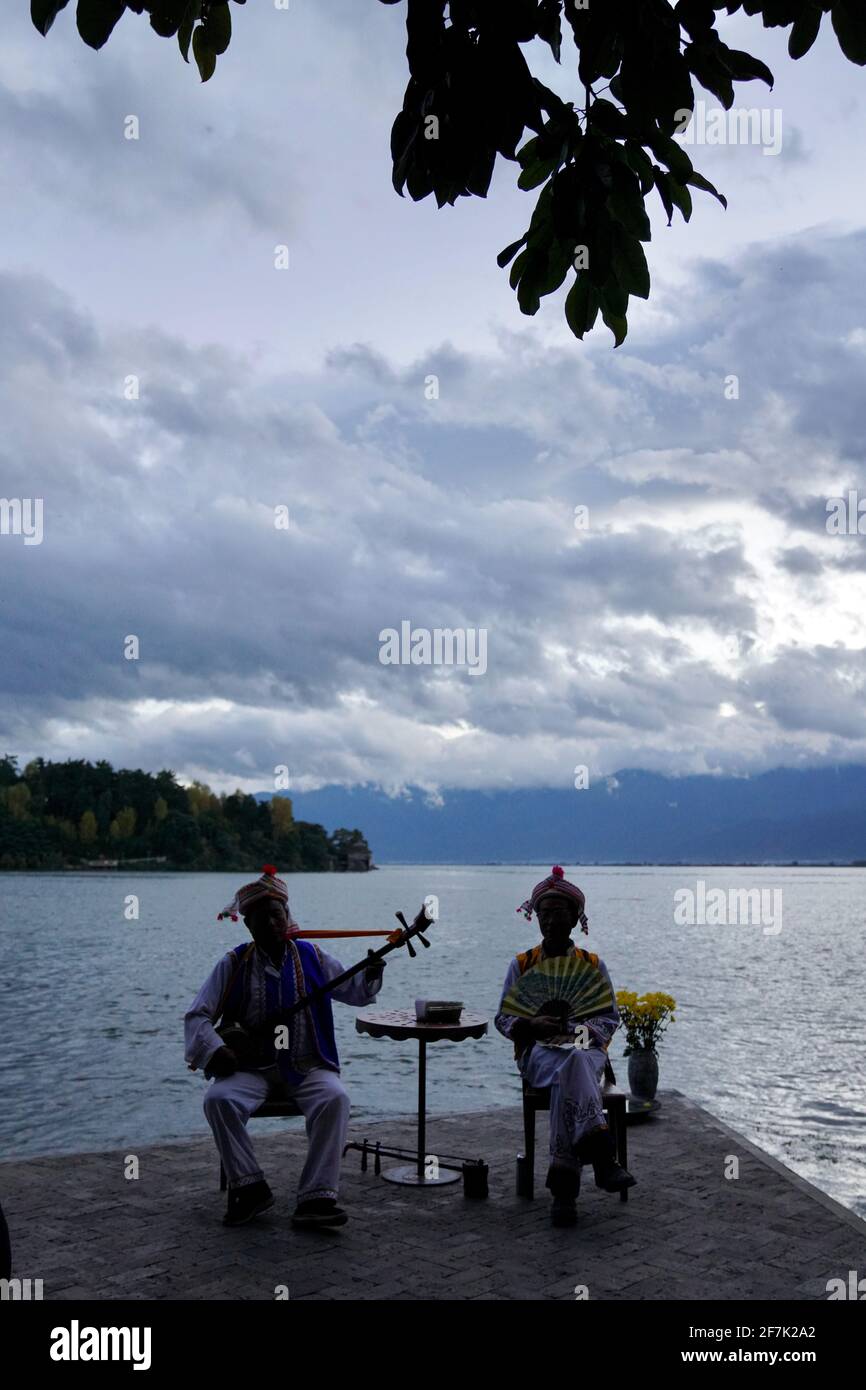 Two elder men dressing up with traditional Bai people and playing ...