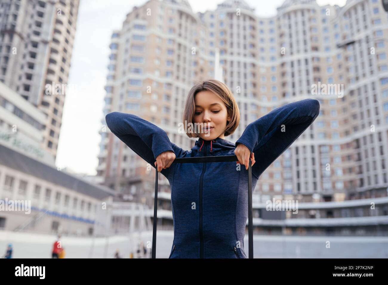 Young sporty woman doing exercises with rubber band outdoor Stock Photo ...