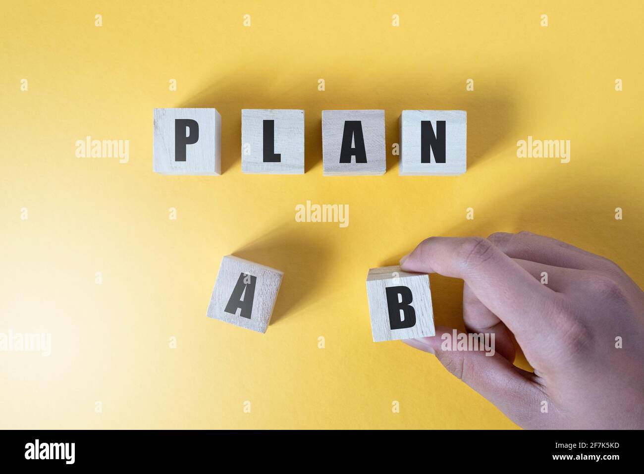 Hand choosing plan B over yellow background. Concept of planning and ...