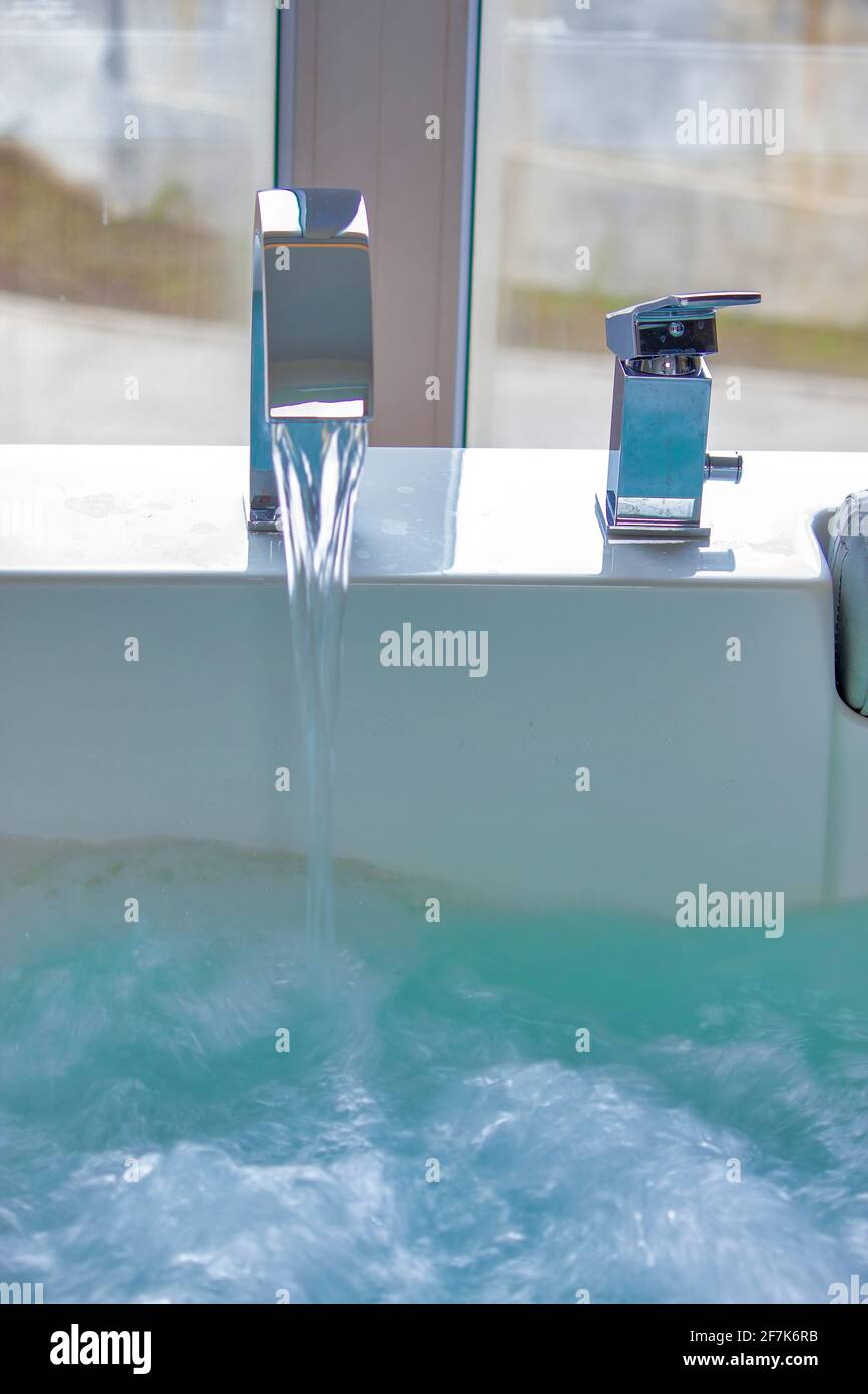 Modern faucet on the hot tub Stock Photo - Alamy