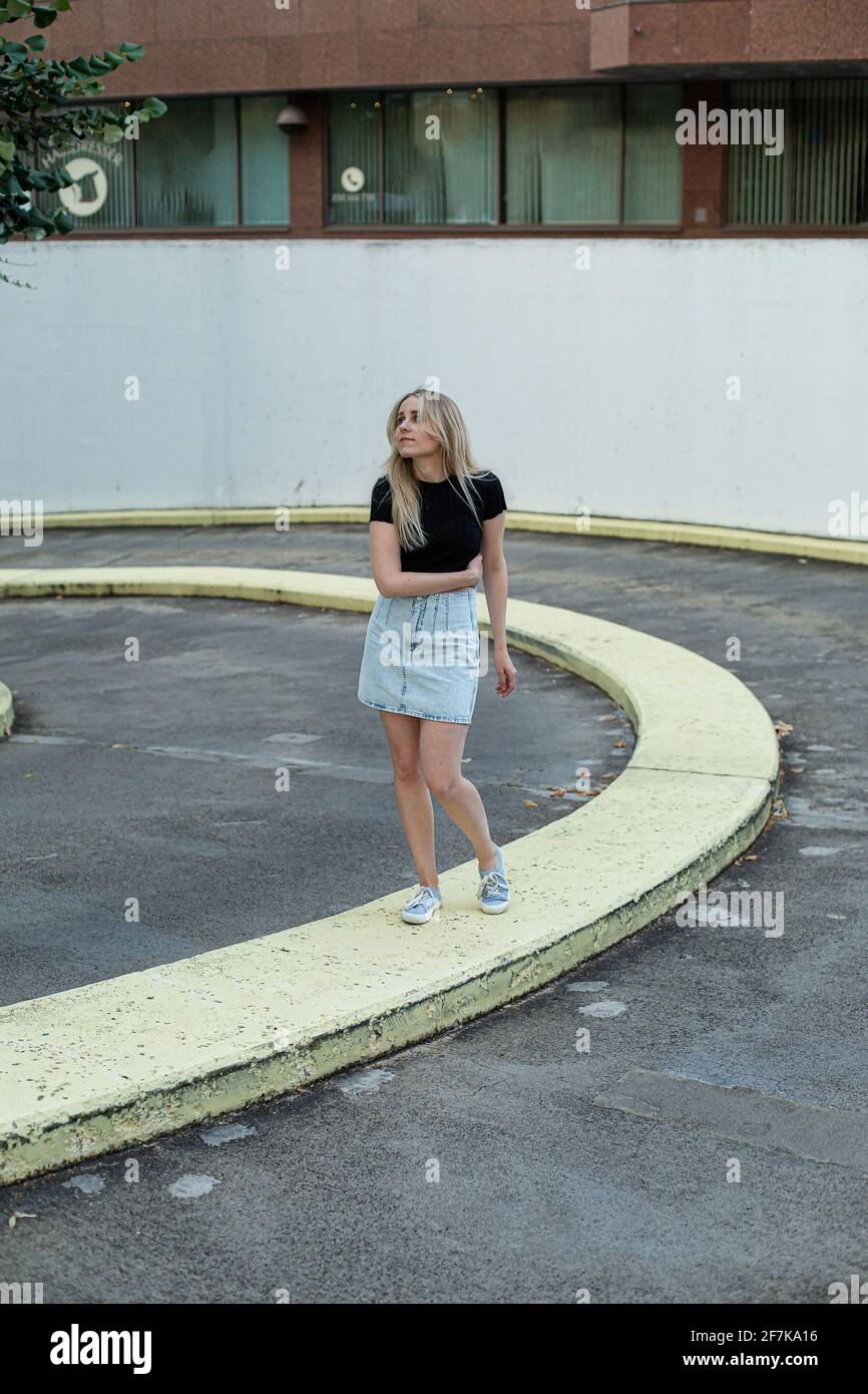 European young white woman walking near concrete underground parking ...