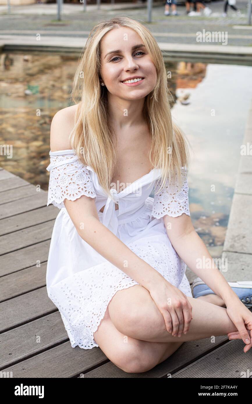 Smiling white european young model with a blonde hair sitting on the ...