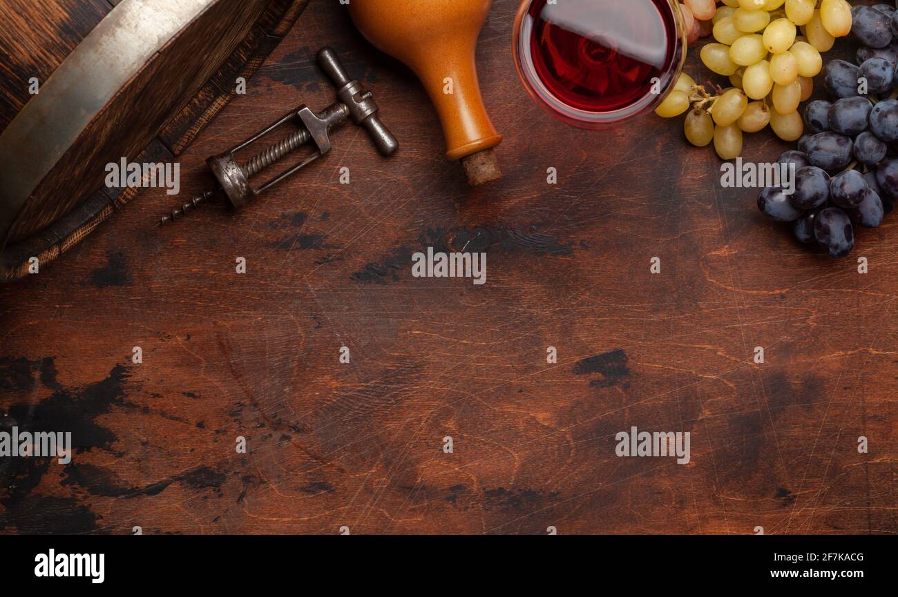 Wine bottle, grapes, glass of red wine and old wooden barrel. Top view ...