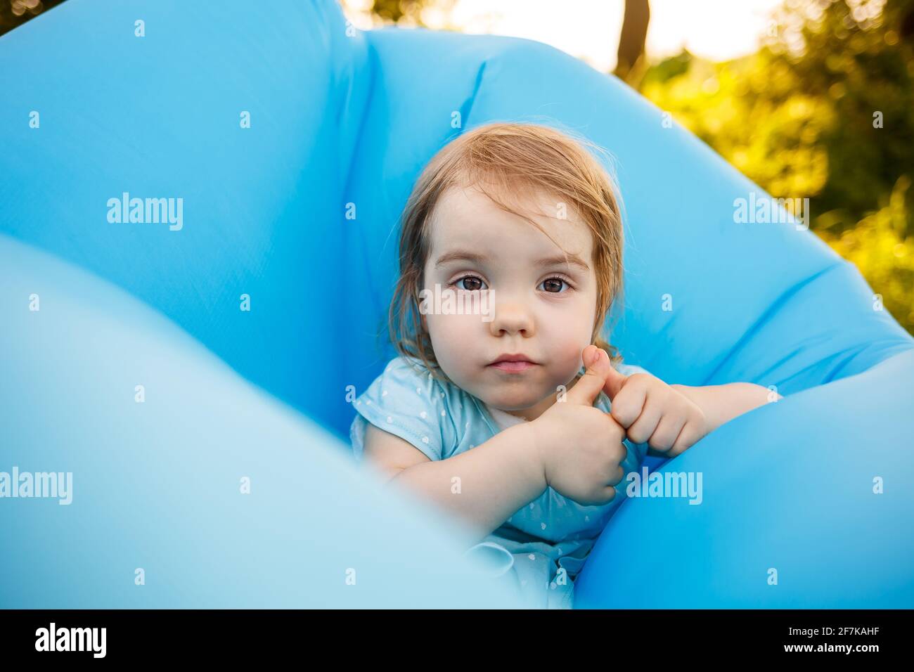 A beautiful little girl is resting and playing in the fresh air ...