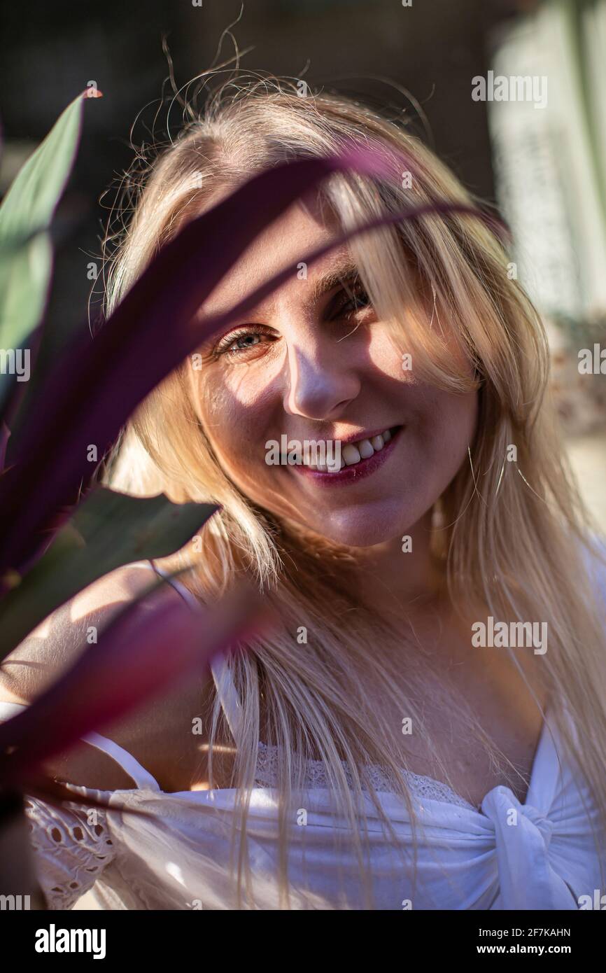 Smiling european white model portrait with a plant Stock Photo - Alamy
