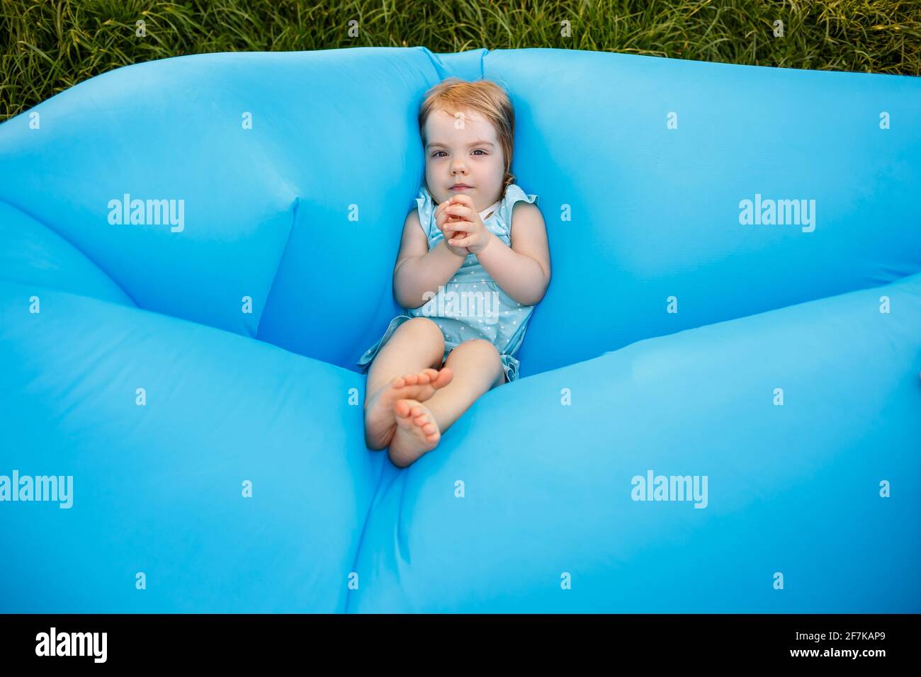 A beautiful little girl is resting and playing in the fresh air ...