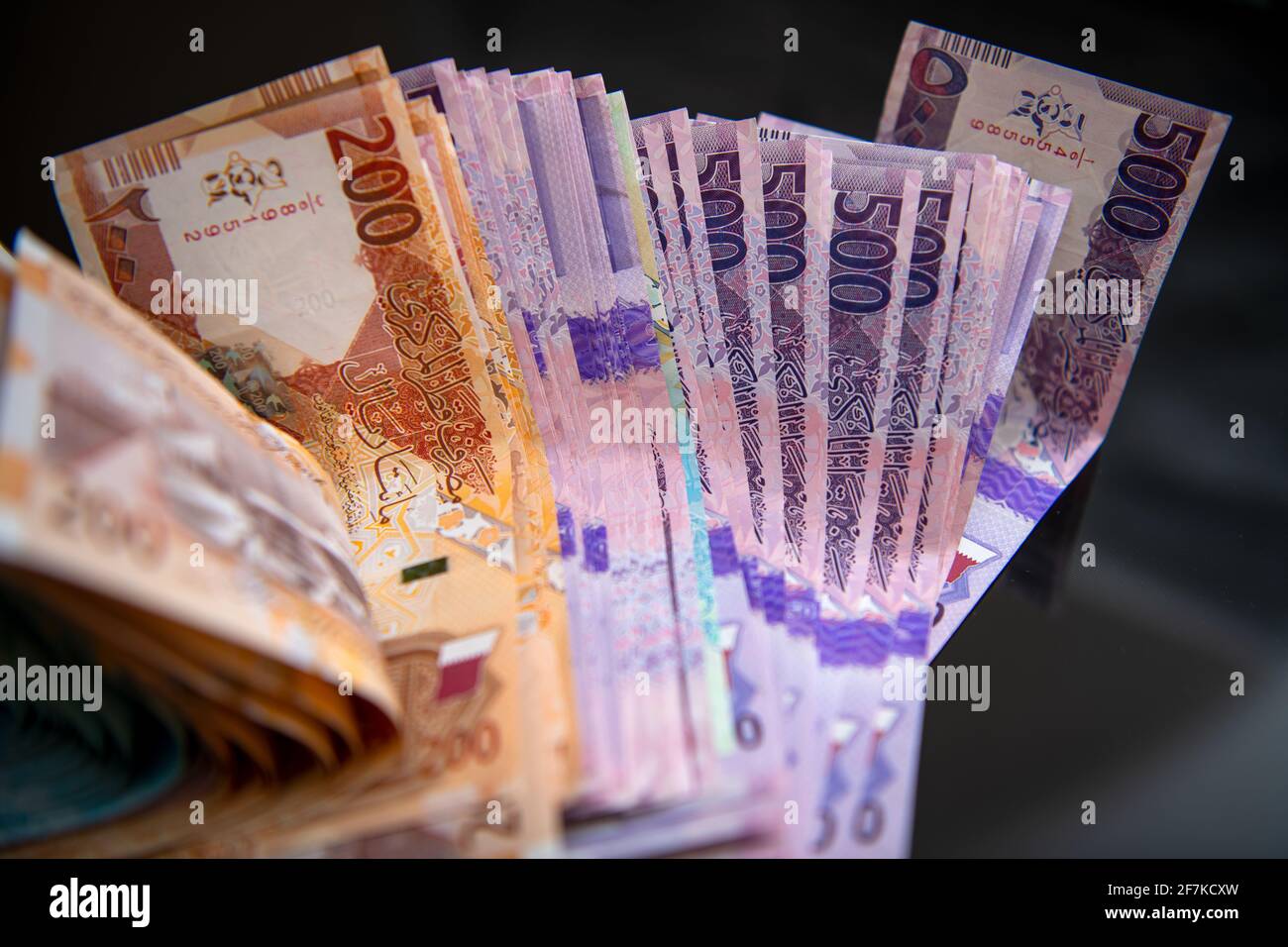 Men's hands holding and Counting Qatari Bank notes. 500 Rial new notes ...