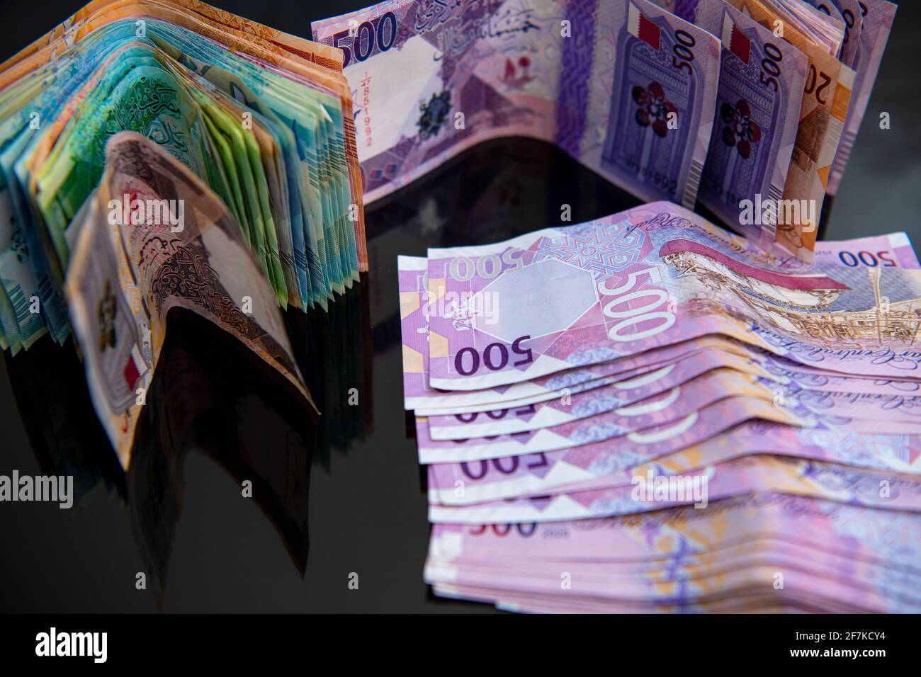 Men's hands holding and Counting Qatari Bank notes. 500 Rial new notes ...