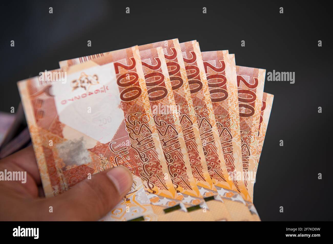 Men's hands holding and Counting Qatari Bank notes. 200 Rial new notes ...
