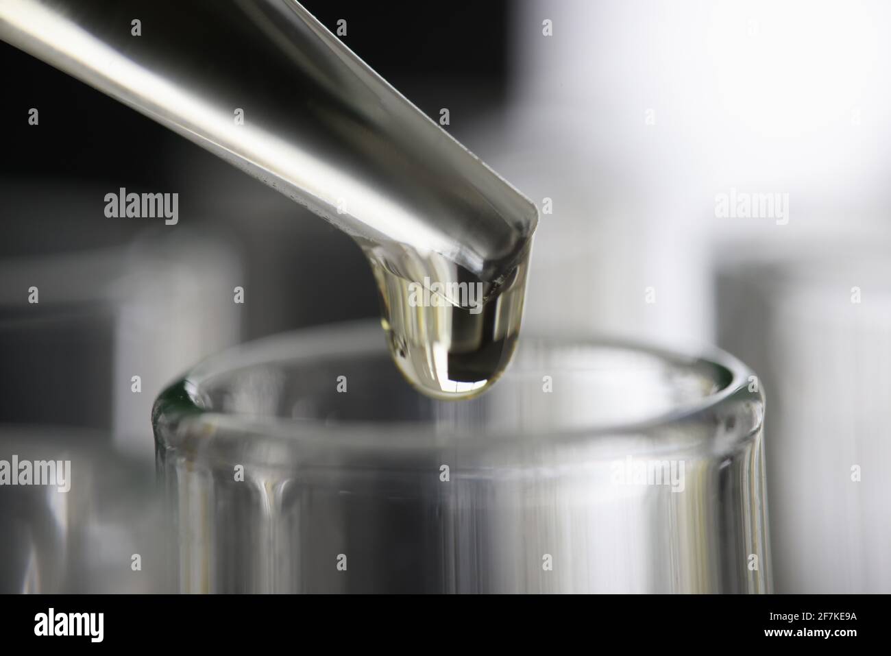 Yellow liquid dripping from pipette into test tube closeup. Scientific ...