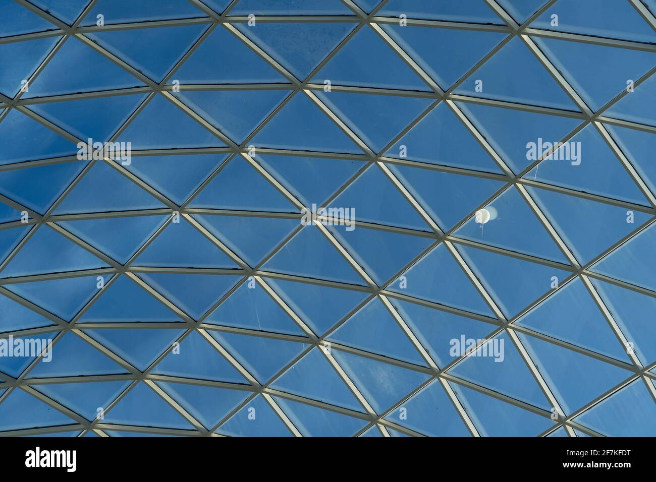 Transparent glass roof of a modern shopping center and a white balloon ...