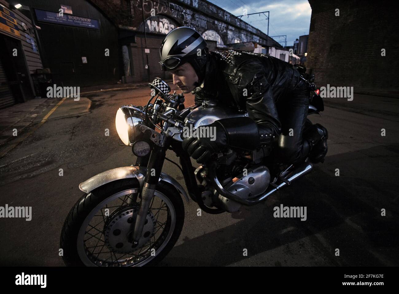 A rider races a cafe racer custom motorcycle in London , Uk Stock Photo ...