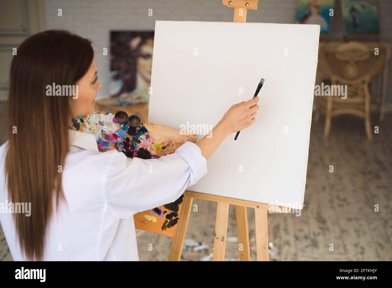 Creative pensive painter paints a colorful picture. Closeup of painting ...