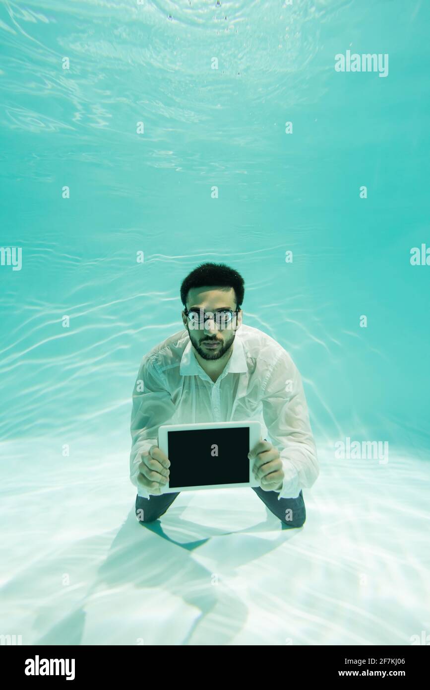 Arabian manager in goggles holding digital tablet underwater Stock ...