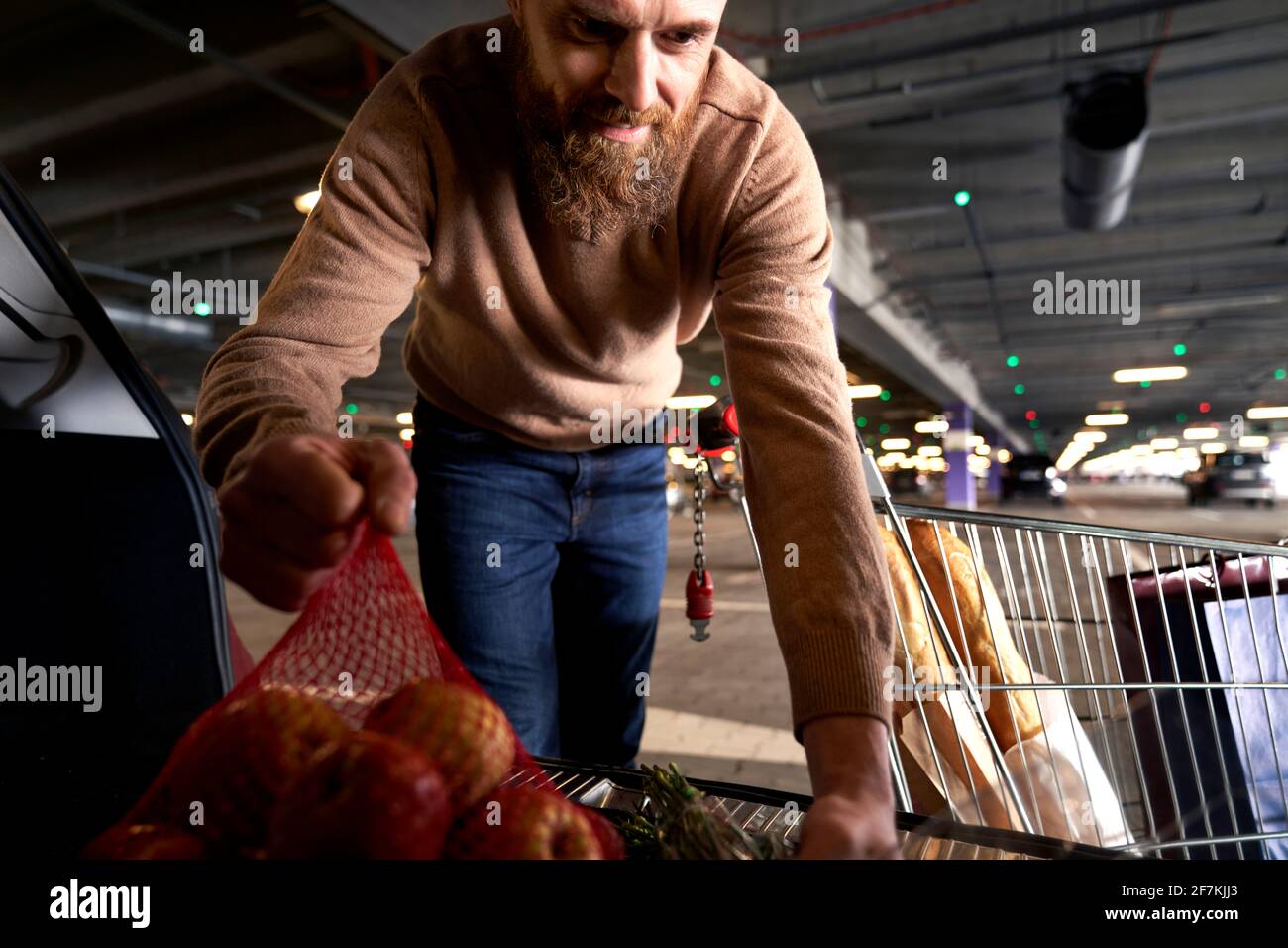 Man packing shopping bags in a car trunk Stock Photo - Alamy