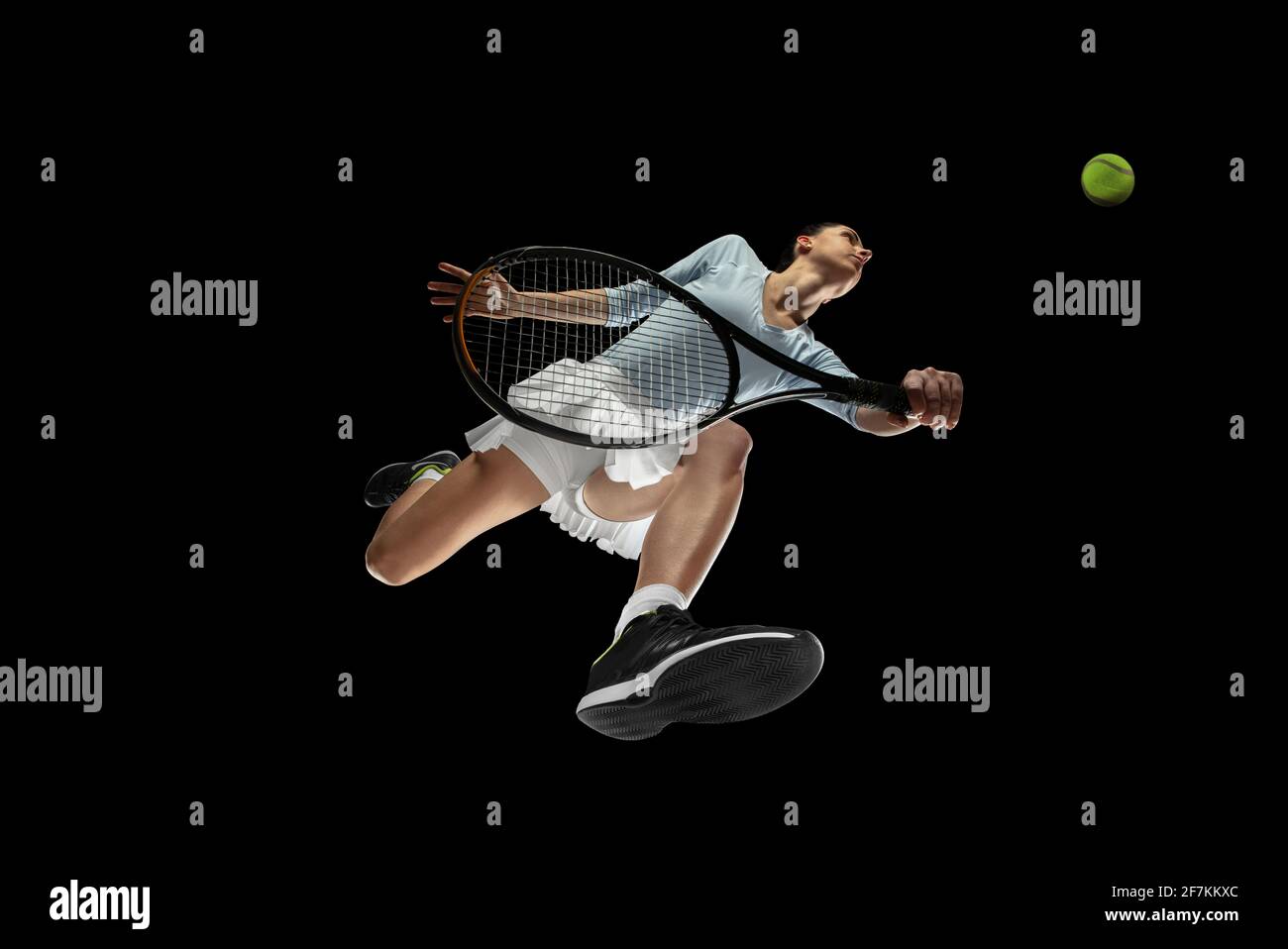 Female professional tennis player in action, motion isolated on black ...