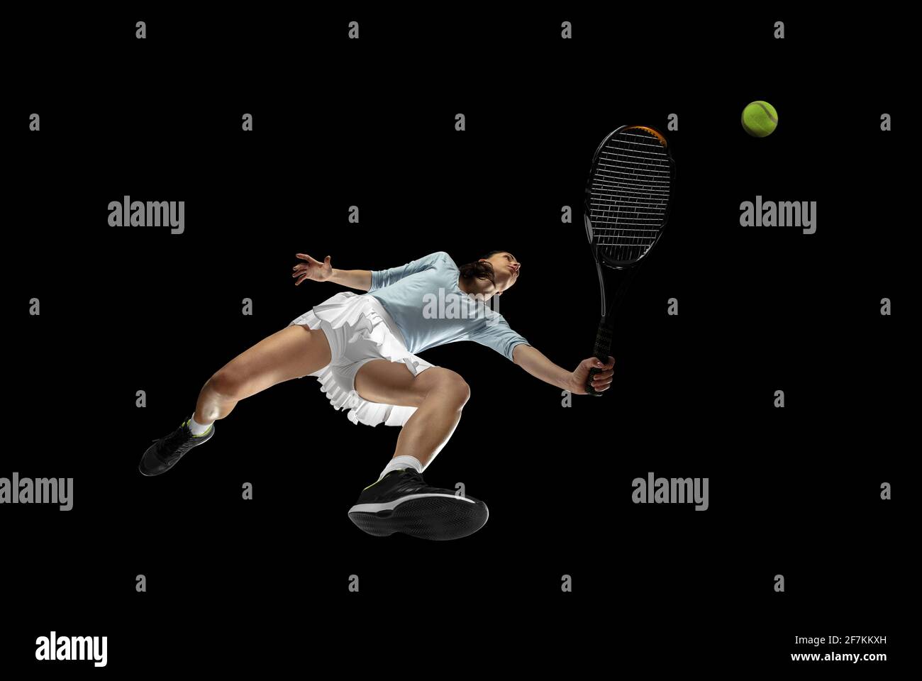 Female professional tennis player in action, motion isolated on black ...