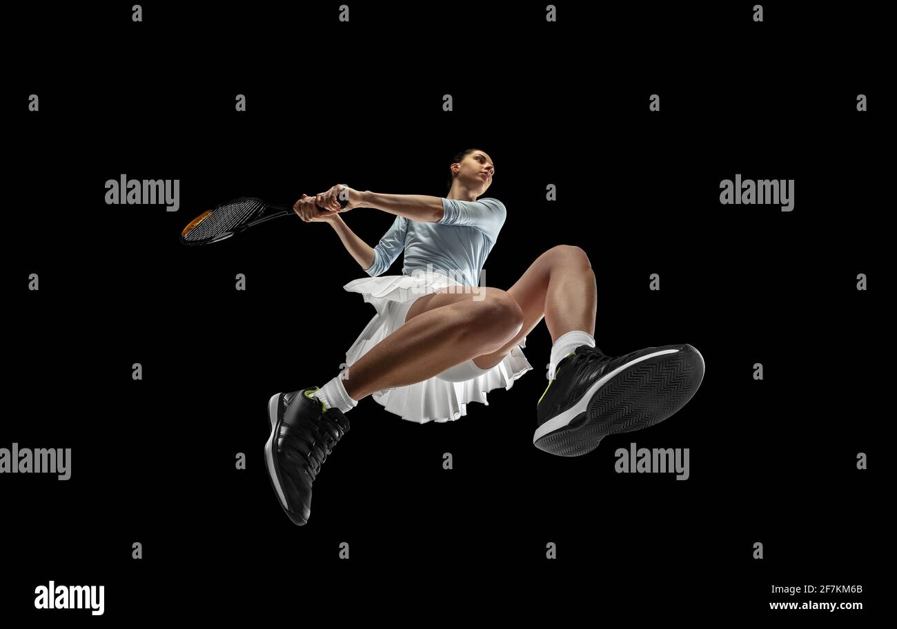 Female professional tennis player in action, motion isolated on black ...