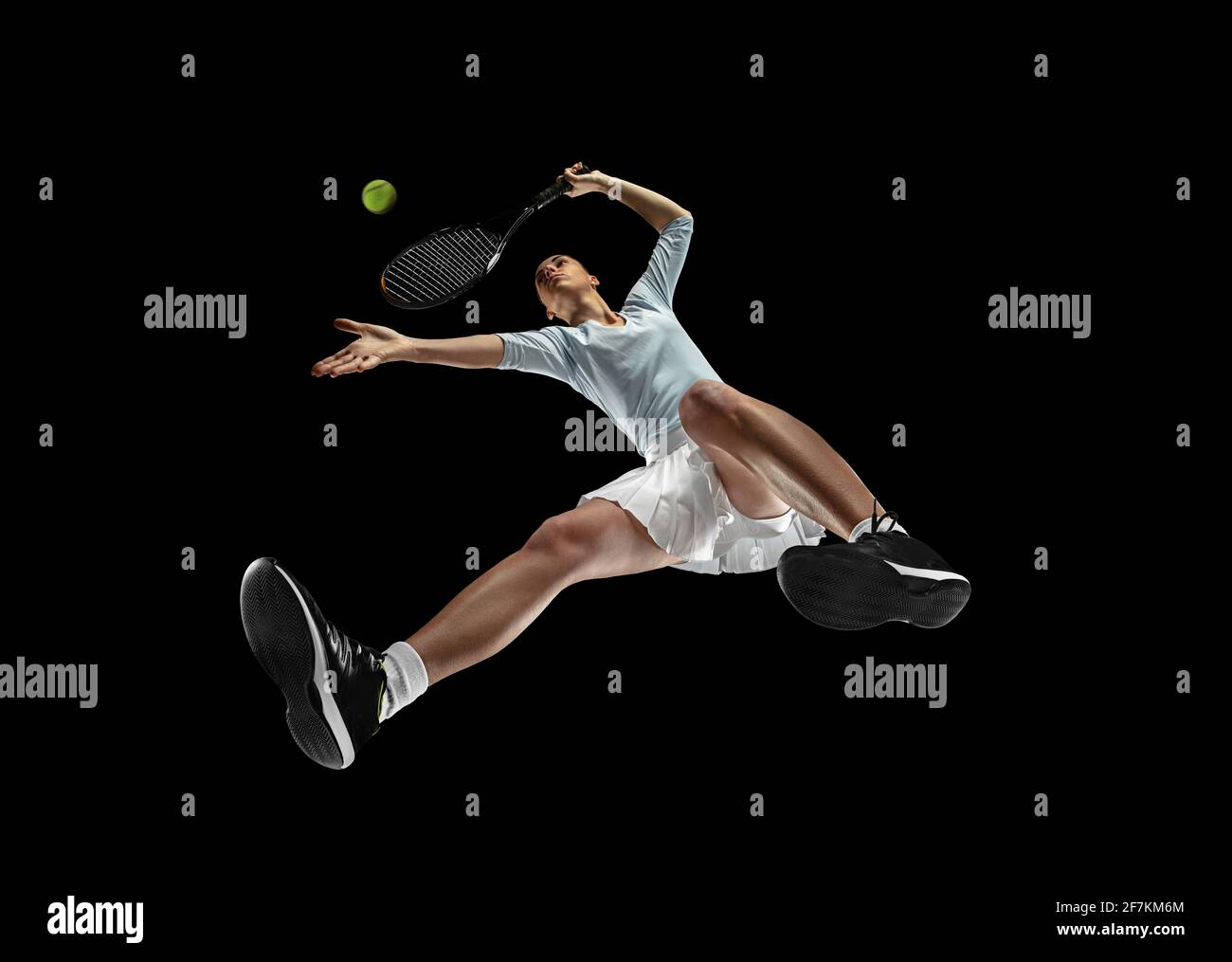 Female professional tennis player in action, motion isolated on black ...