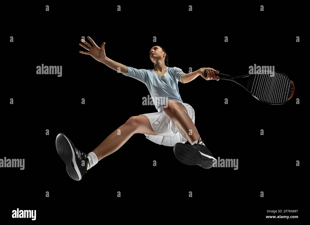 Female professional tennis player in action, motion isolated on black ...