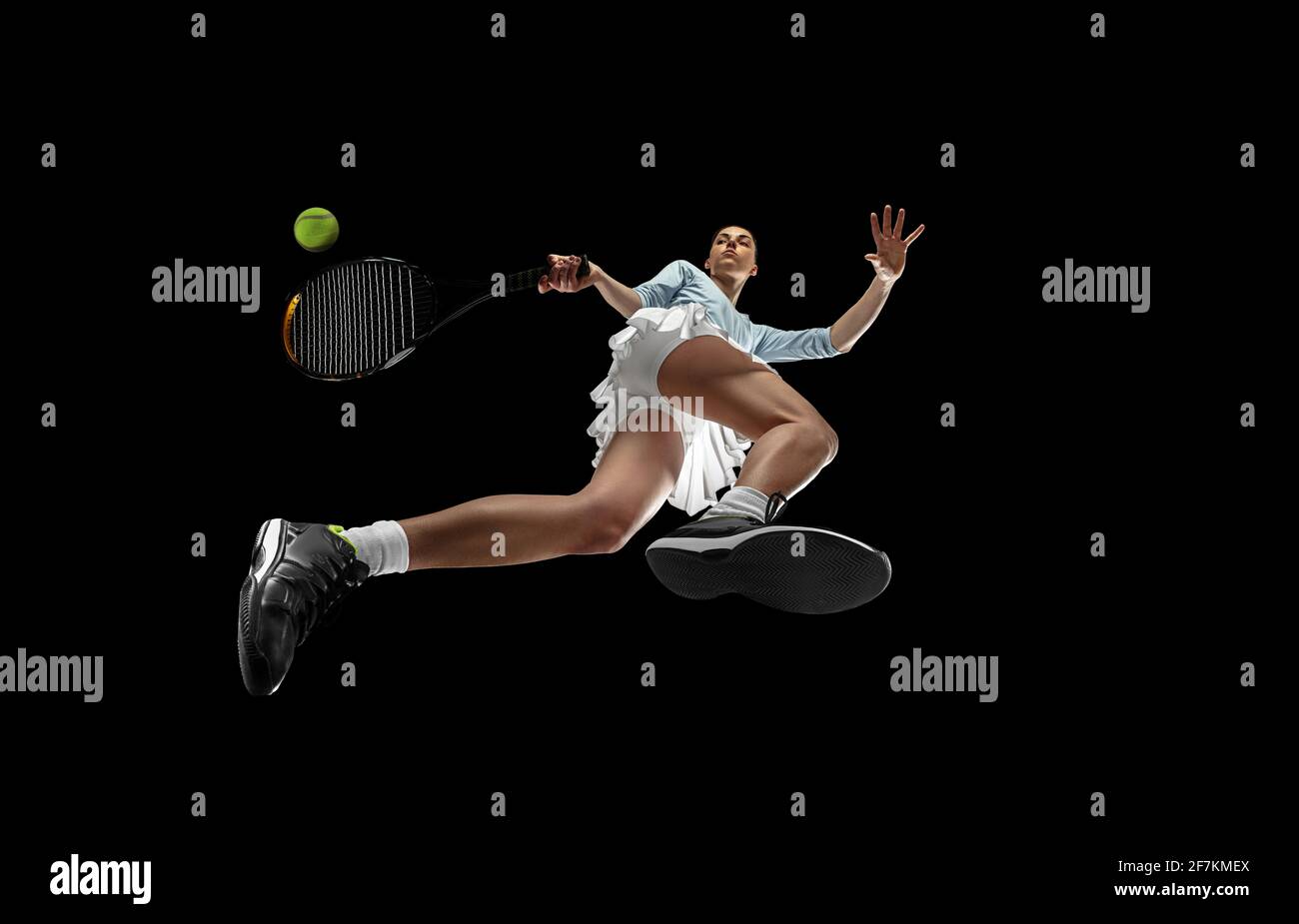Female professional tennis player in action, motion isolated on black ...