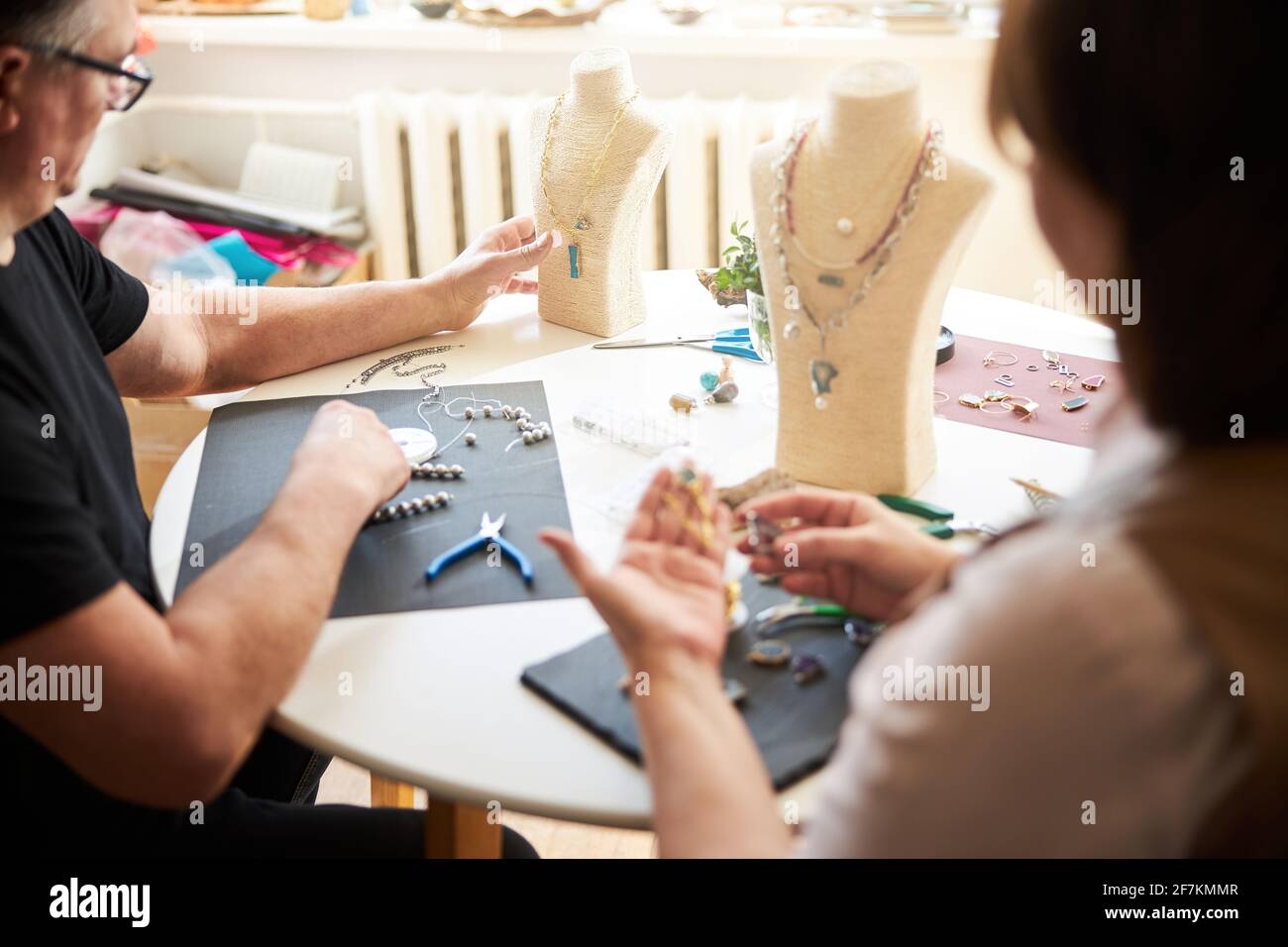 Two professional jewelers creating necklaces in their workshop Stock ...
