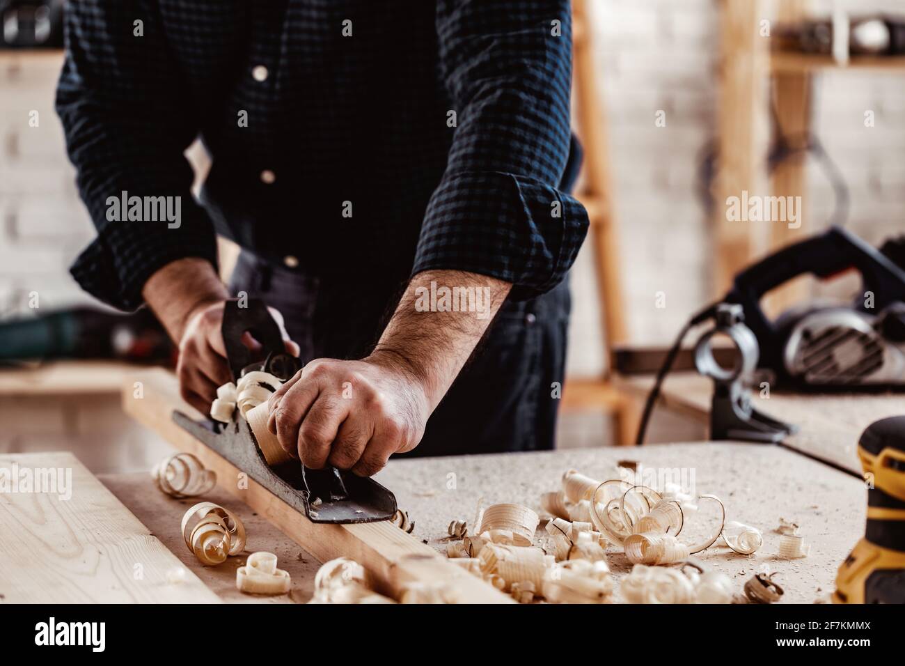 Carpenter's hands planing a plank of wood with a hand plane Stock Photo ...