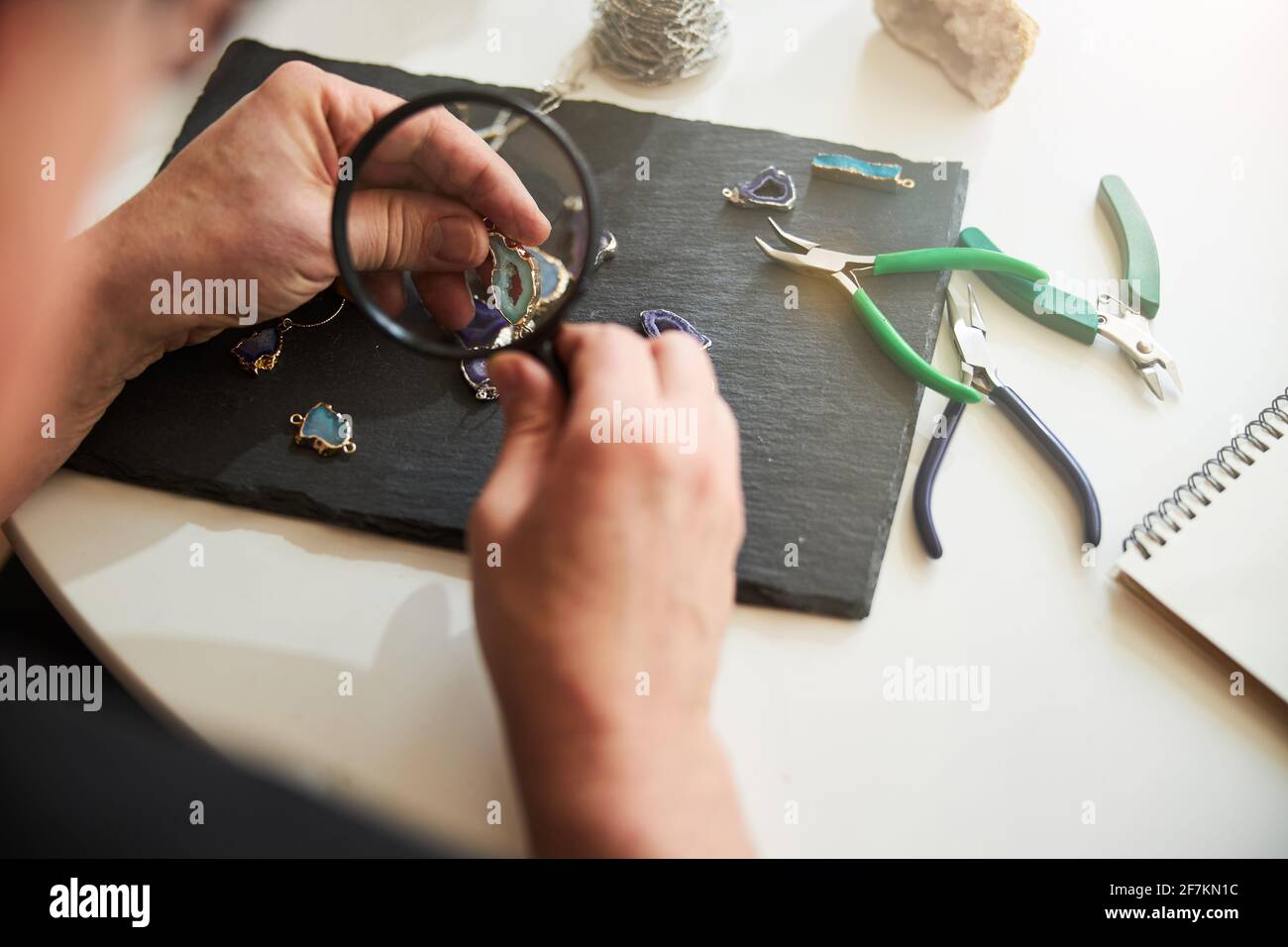 Jeweler checking the quality of his new jewelry item Stock Photo - Alamy