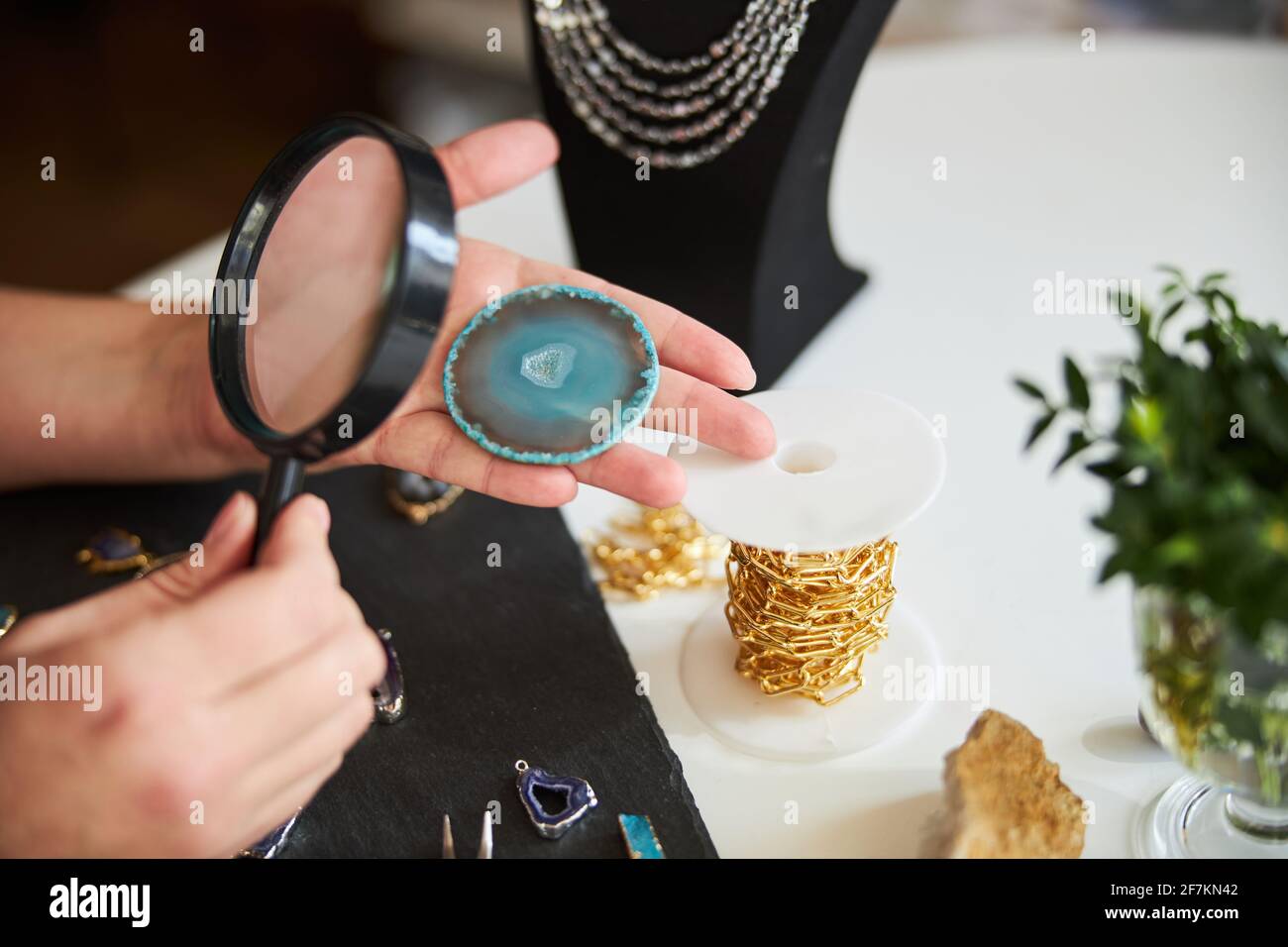 Female master examining a gemstone slice for flaws Stock Photo - Alamy