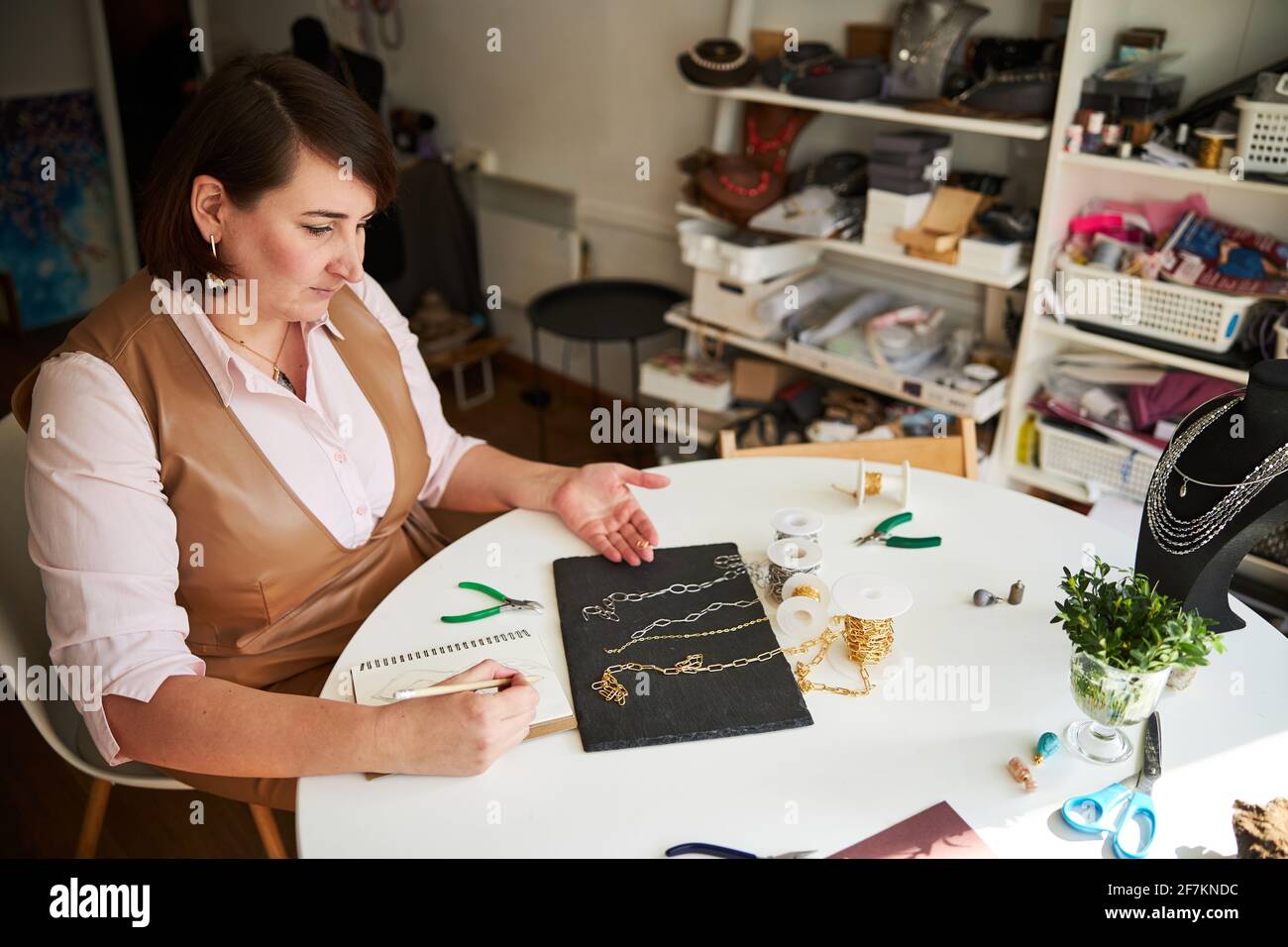 Experienced jeweler drawing with a pencil in her notebook Stock Photo ...