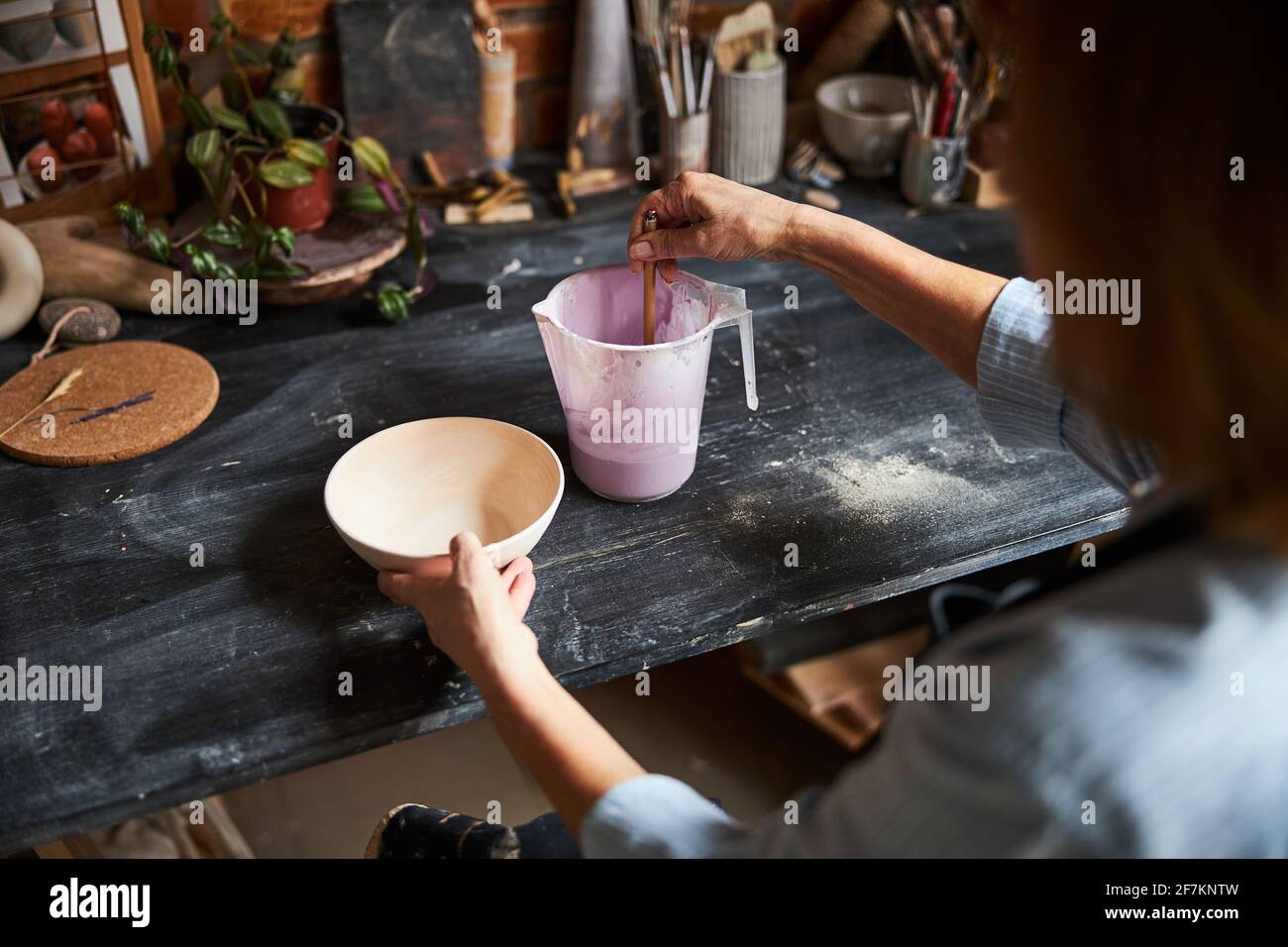 Female ceramic artist painting pottery in workshop Stock Photo - Alamy
