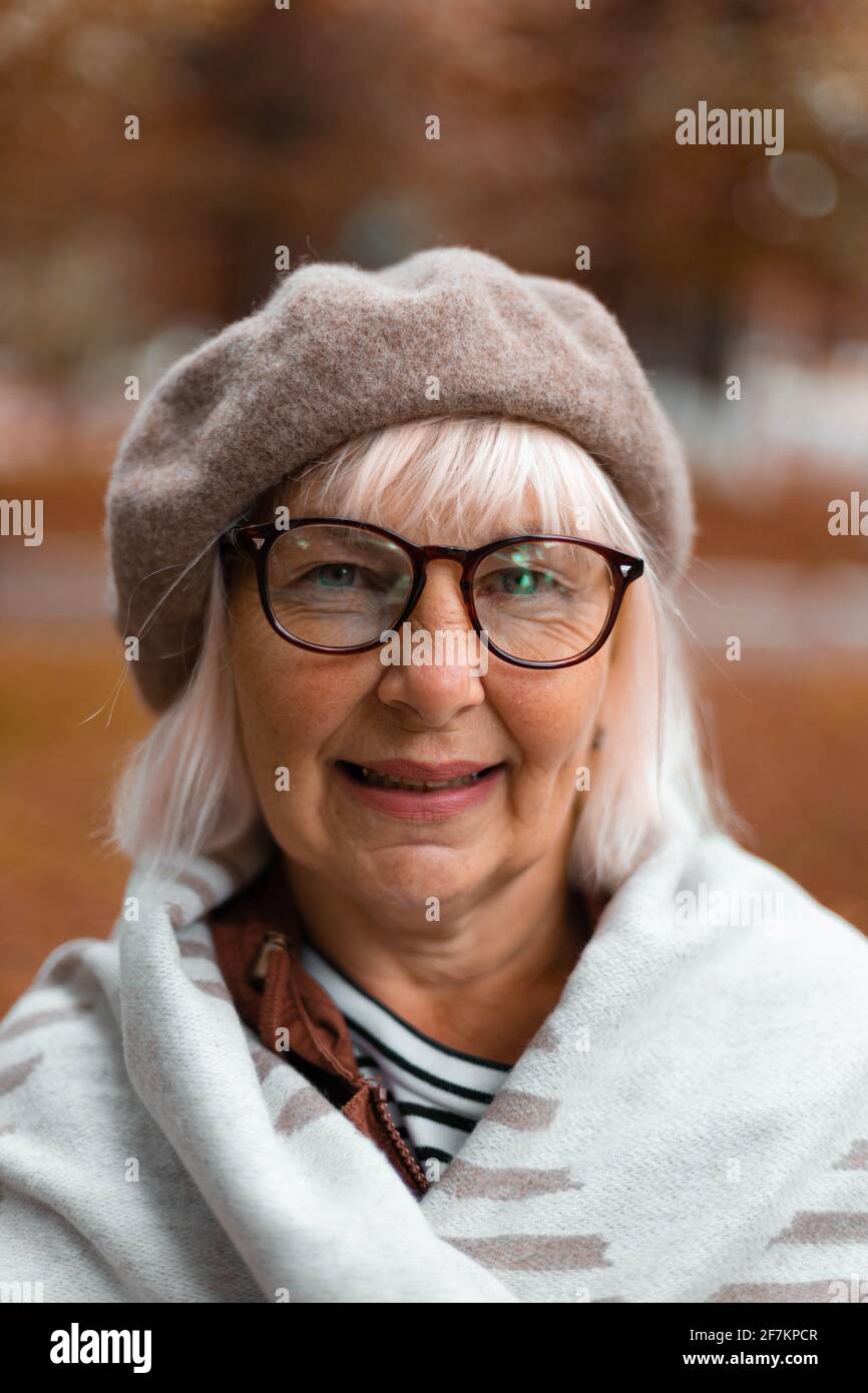 Happy Caucasian lady in stylish beret, cozy blanket on a walk on a ...