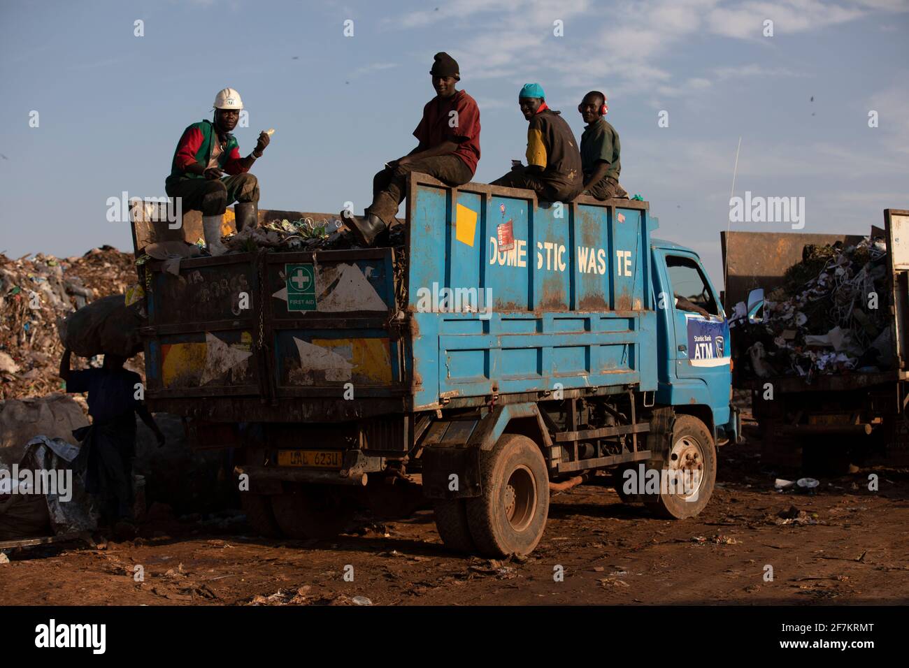 KAMPALA, UGANDA: Workers sit on the edges of a dump truck. IMAGES ...