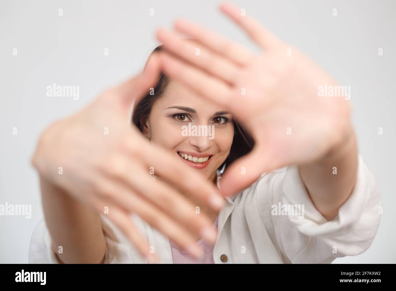 Hand framing woman portrait. Selective focus on face Stock Photo - Alamy